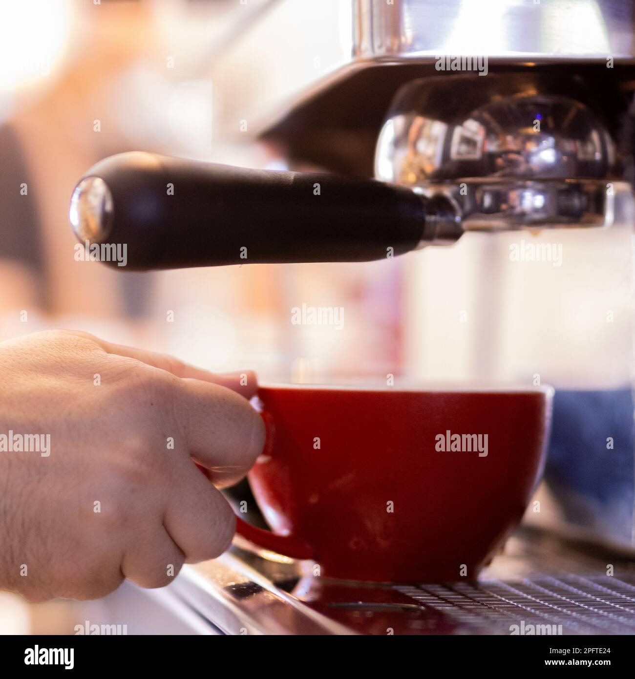 Bartender working on coffee machine in red cup Stock Photo - Alamy