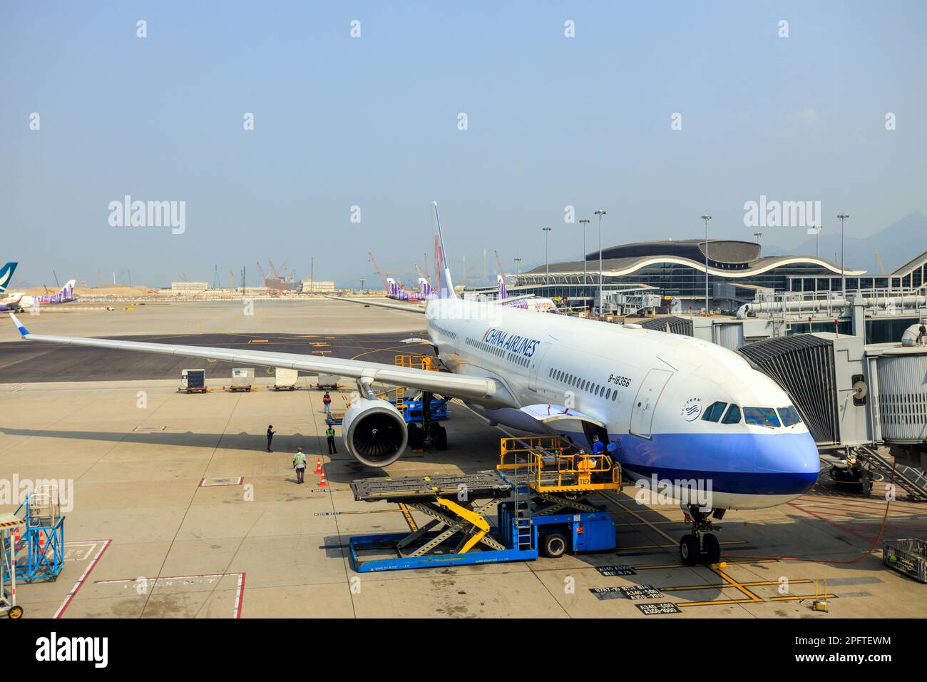 Hong Kong - March 1, 2023: Airplane at boarding gate jet bridge in Hong ... Hong Kong - March 1, 2023: Airplane at boarding gate jet bridge in Hong ...