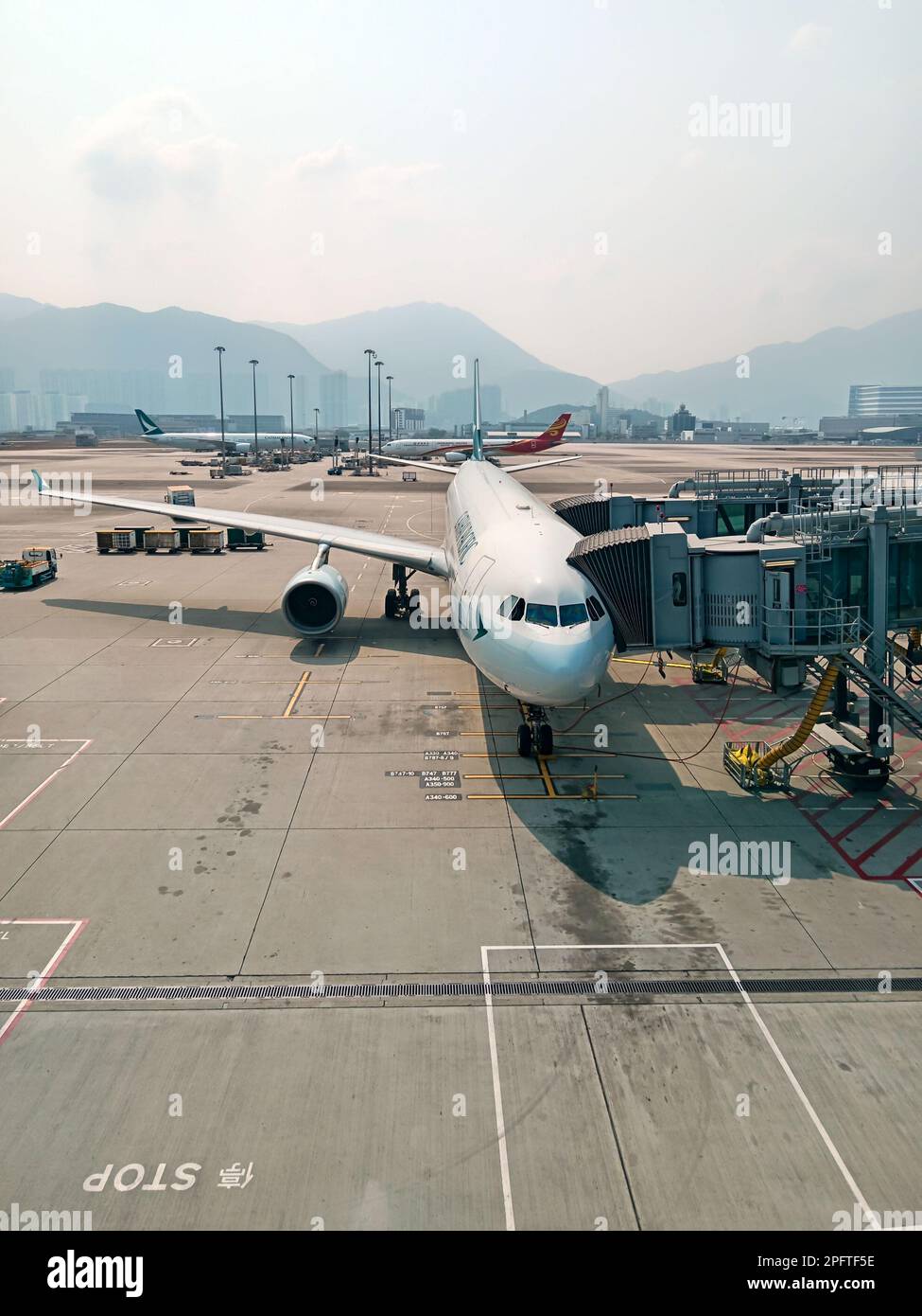 Hong Kong - March 1, 2023: Airplane at boarding gate jet bridge in Hong ... Hong Kong - March 1, 2023: Airplane at boarding gate jet bridge in Hong ...