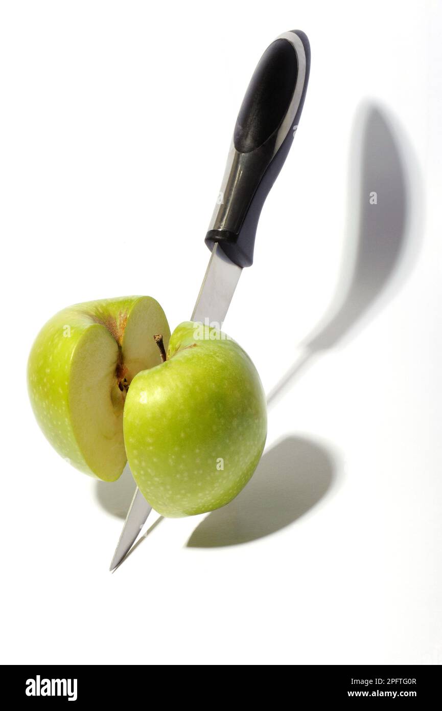 floating green apple cut in half by knife on white background Stock ...
