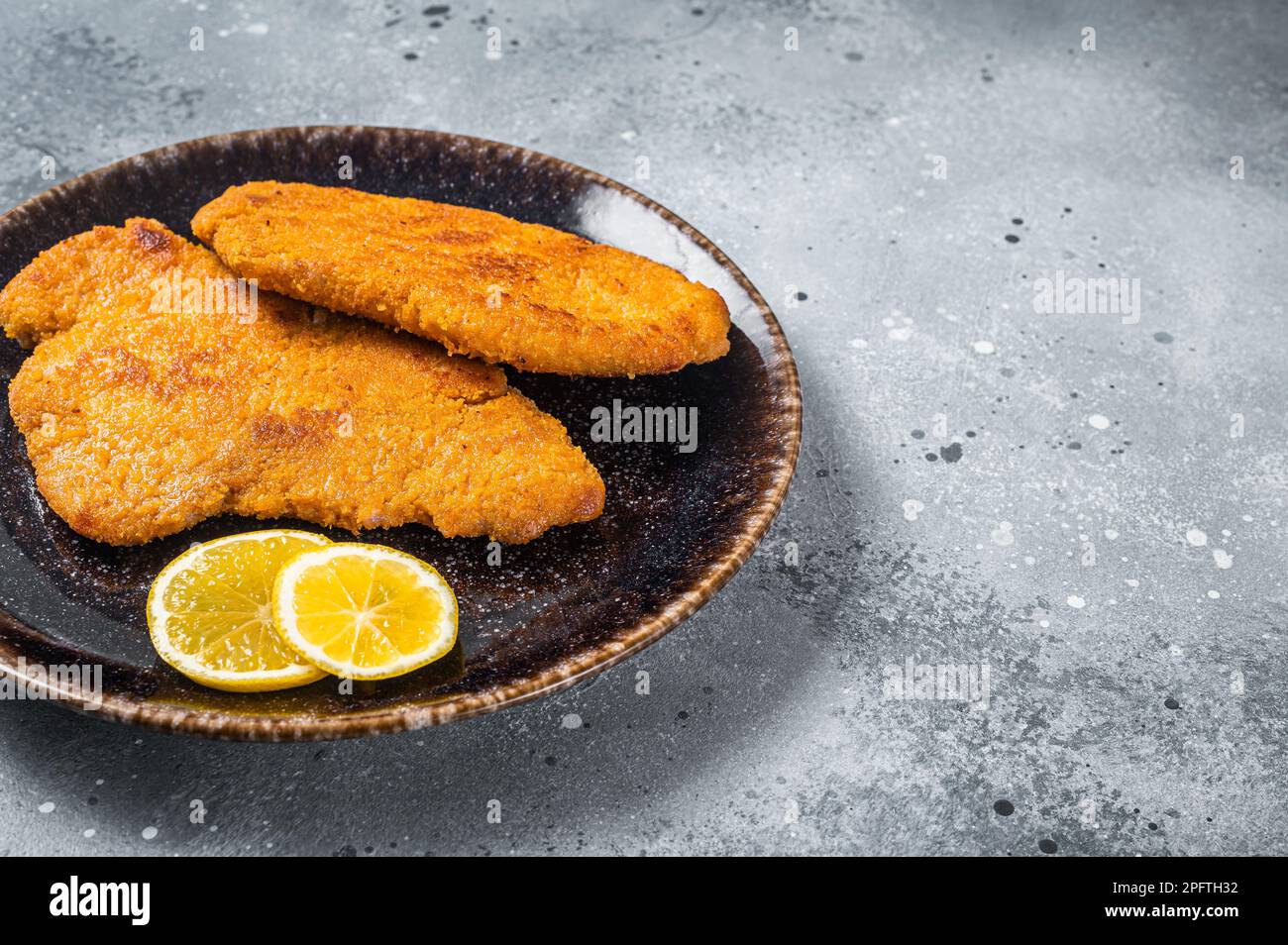 Roasted breaded german weiner schnitzel on a plate. Gray background ...