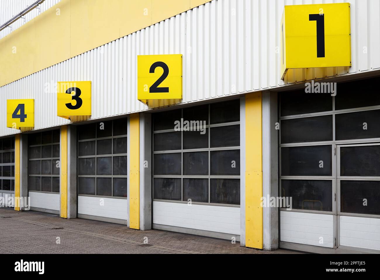 industrial warehouse building with numbered roll-up doors Stock Photo ...