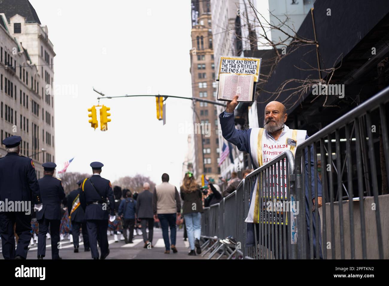 A religious passerby holds a sign and a bible about the end of the ...