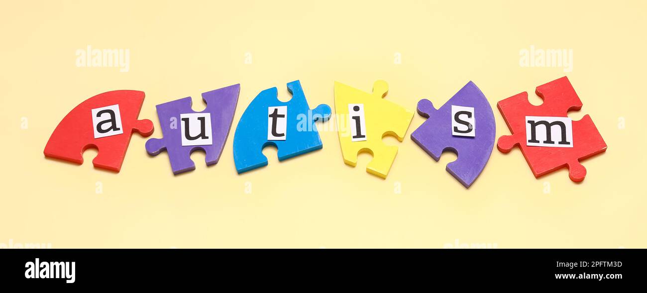 Word AUTISM and jigsaw puzzle pieces on beige background Stock Photo ...