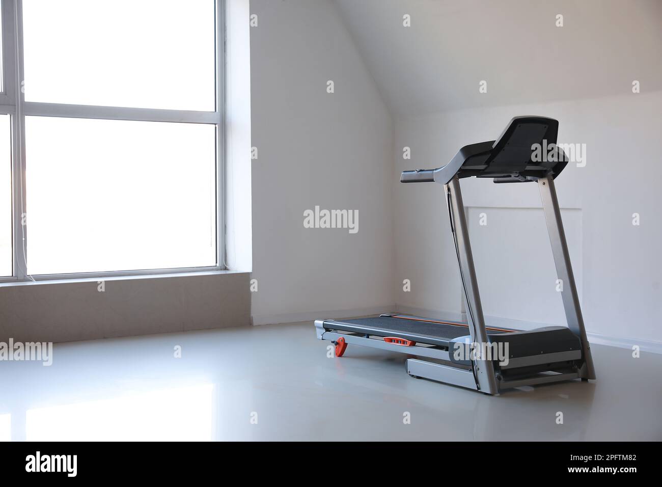 Interior of room with modern treadmill near window Stock Photo - Alamy