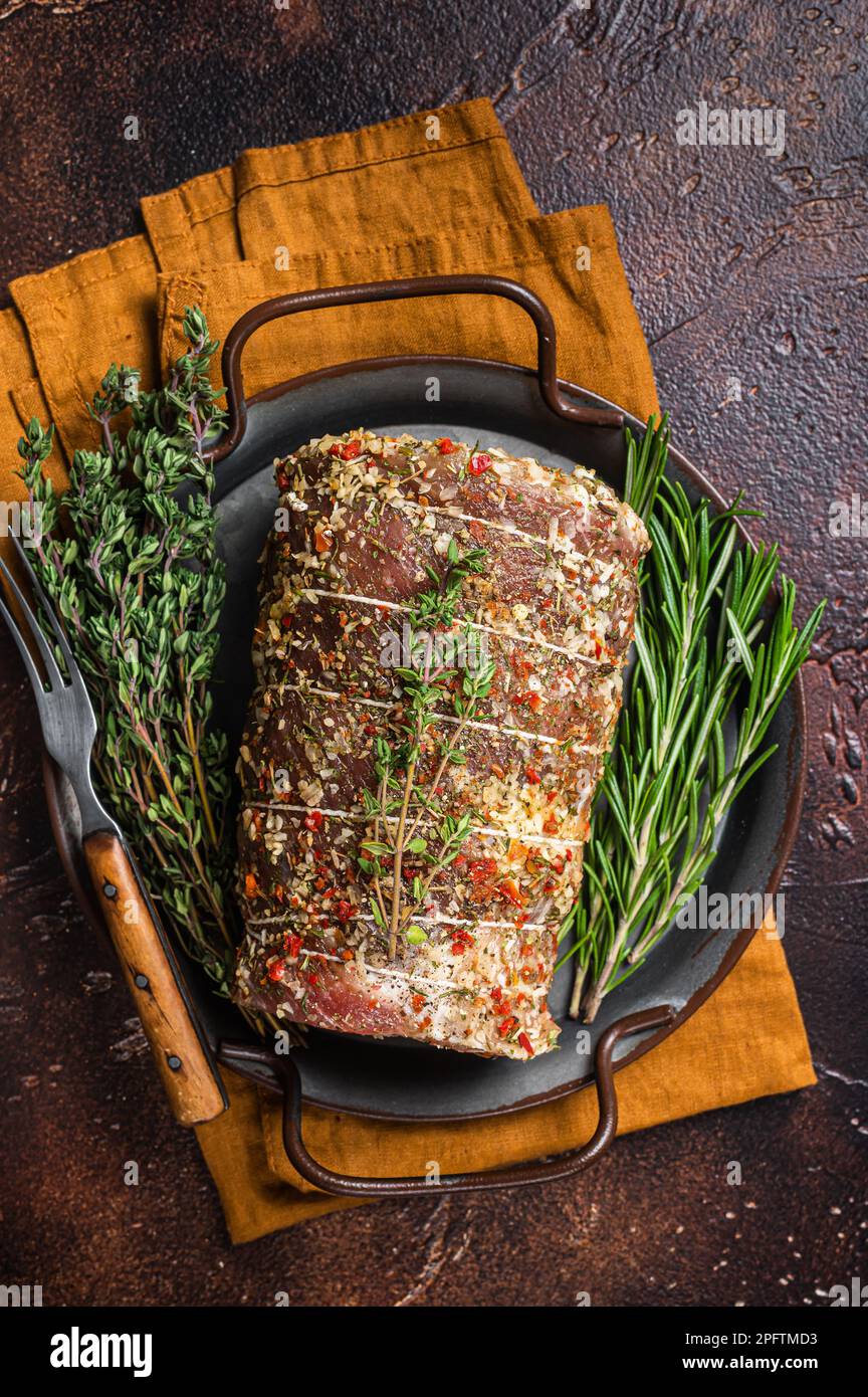 Rolled meat pork roulade with rosemary and thyme. Dark background. Top ...