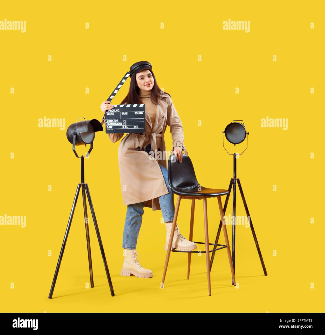 Female film director with movie clapper on yellow background Stock ...