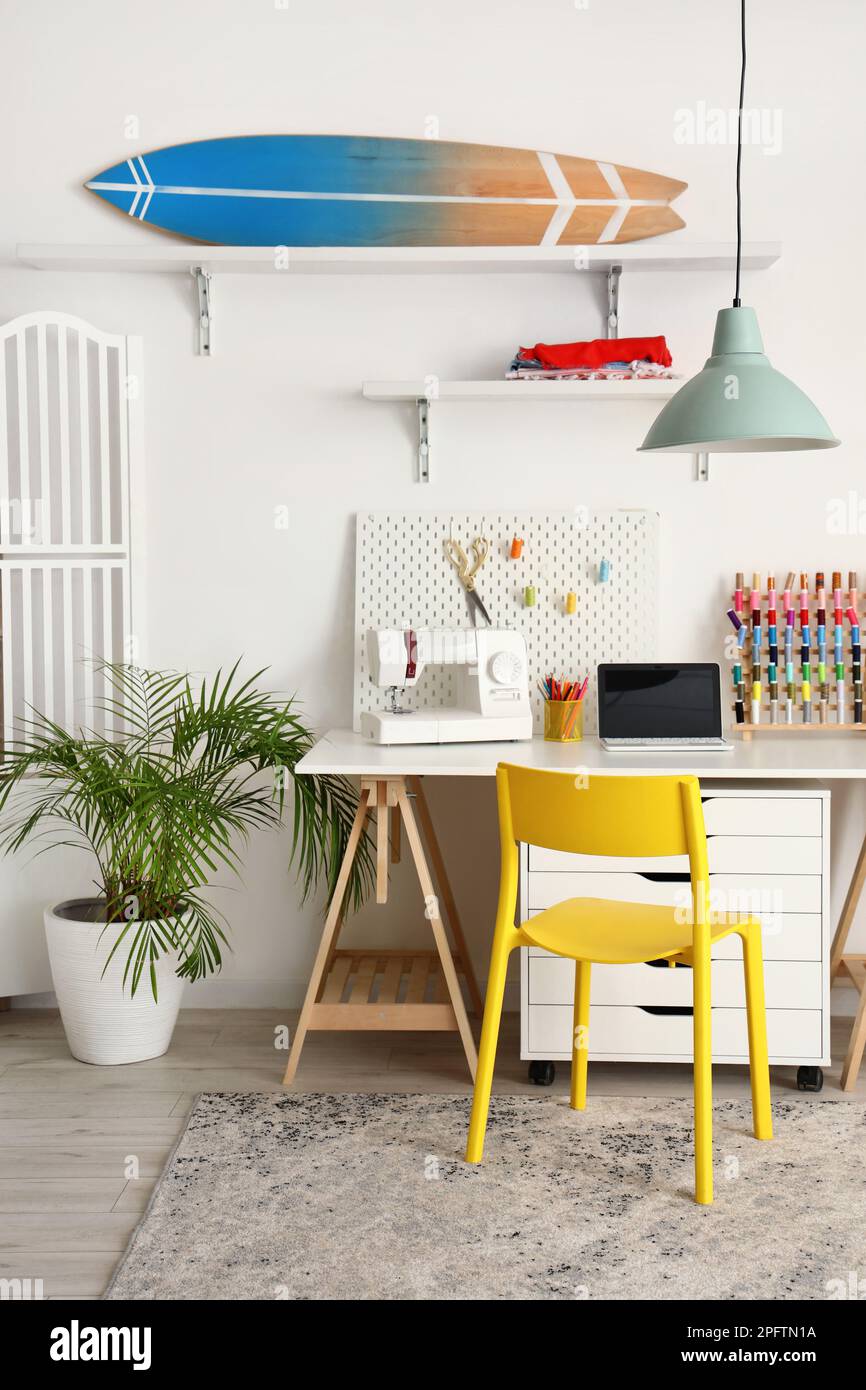 Interior of modern atelier with tailor's workplace, shelves and ...