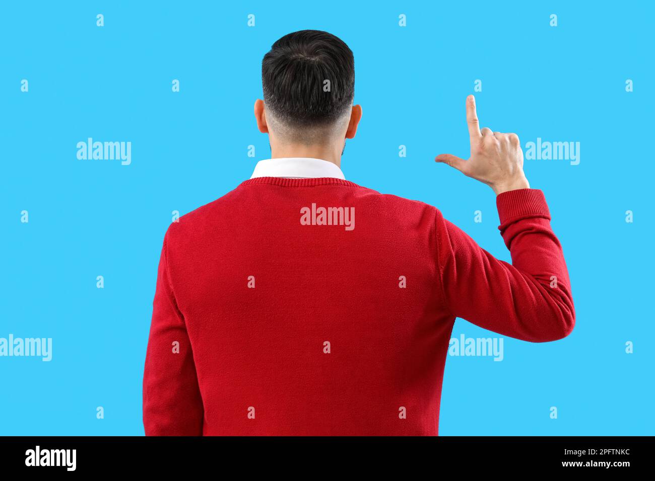 Handsome man showing loser gesture on blue background, back view Stock ...