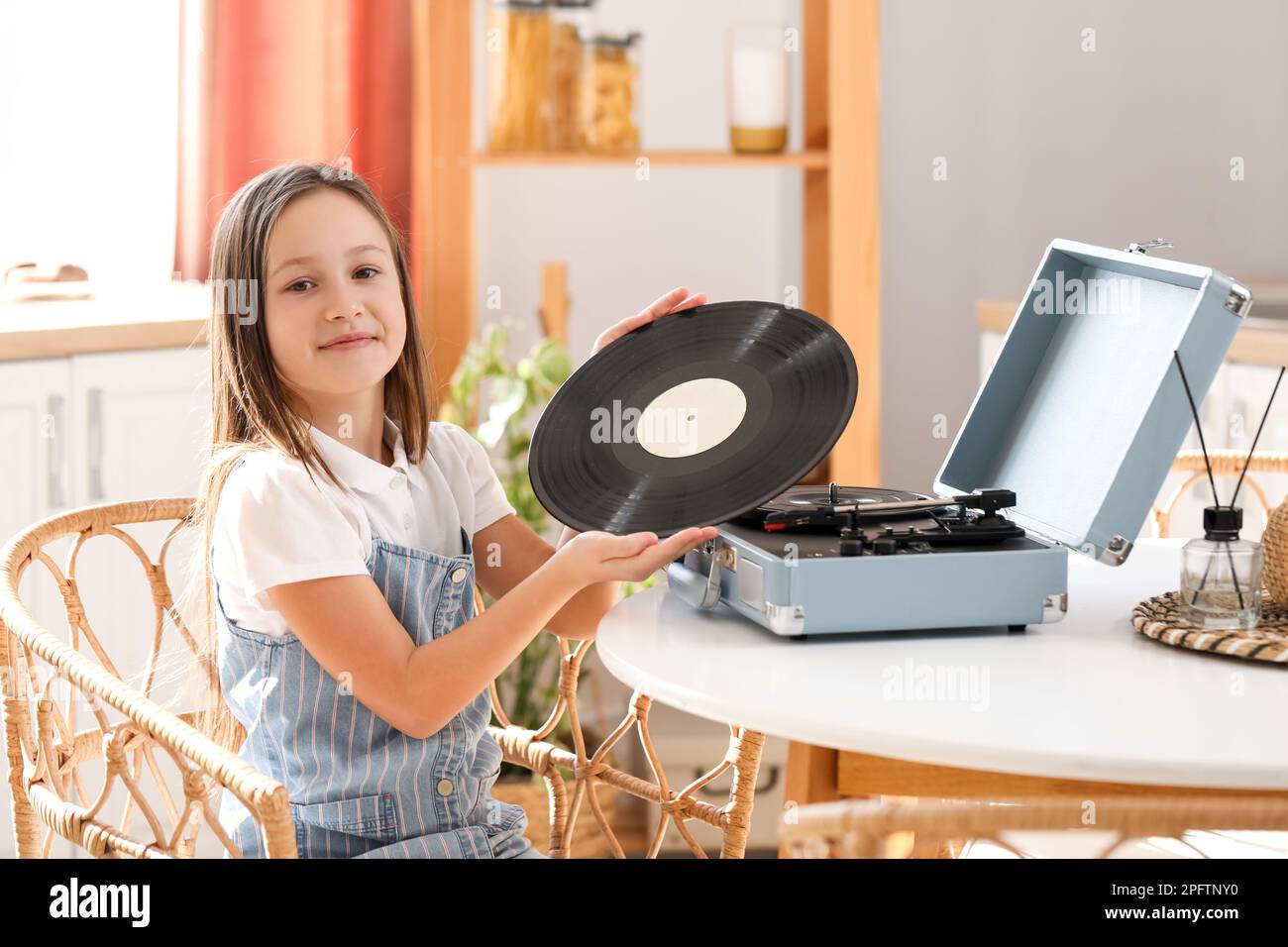 Little girl with vinyl disc and record player at table in kitchen Stock ...
