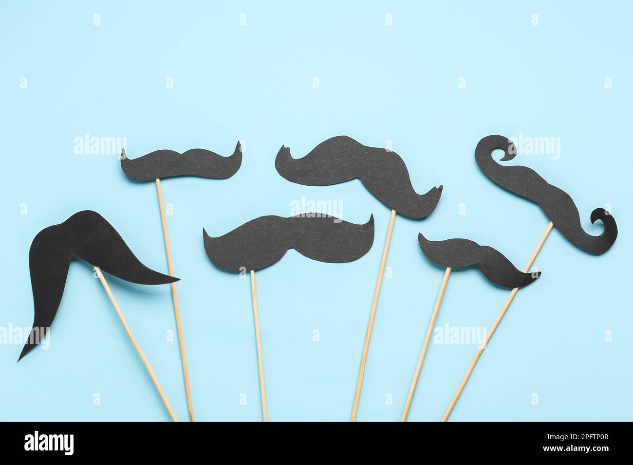 Set of different paper mustaches on sticks against color background ...