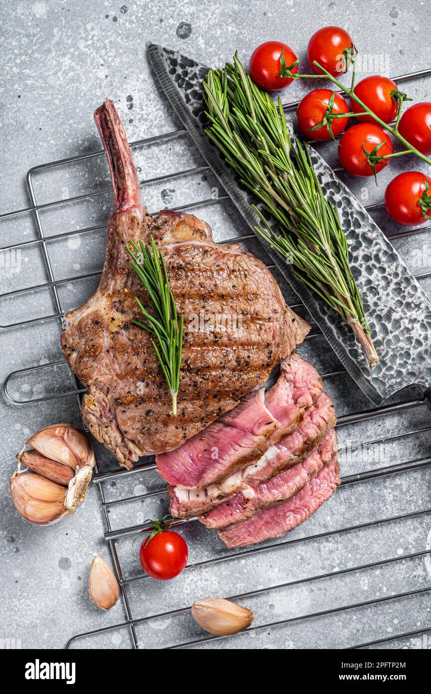BBQ roasted sliced rib eye Tomahawk beef steak on grill. Gray ...