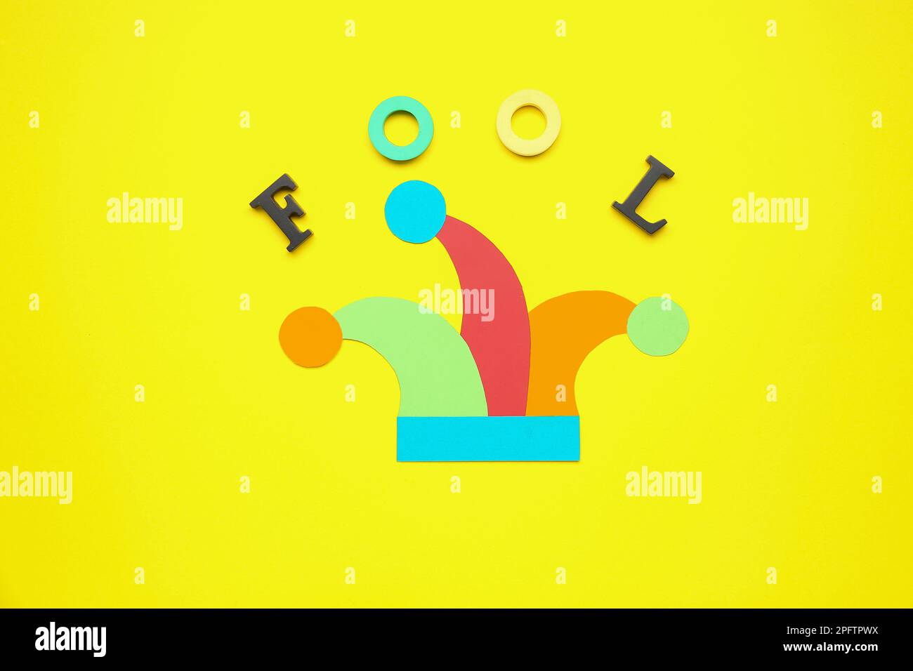 Paper hat with word FOOL on yellow background Stock Photo - Alamy