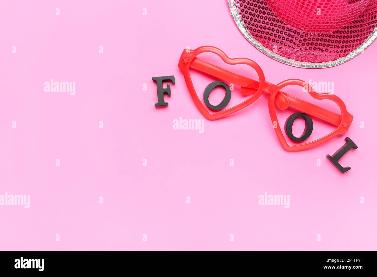 Word FOOL with eyeglasses and party hat on pink background Stock Photo ...