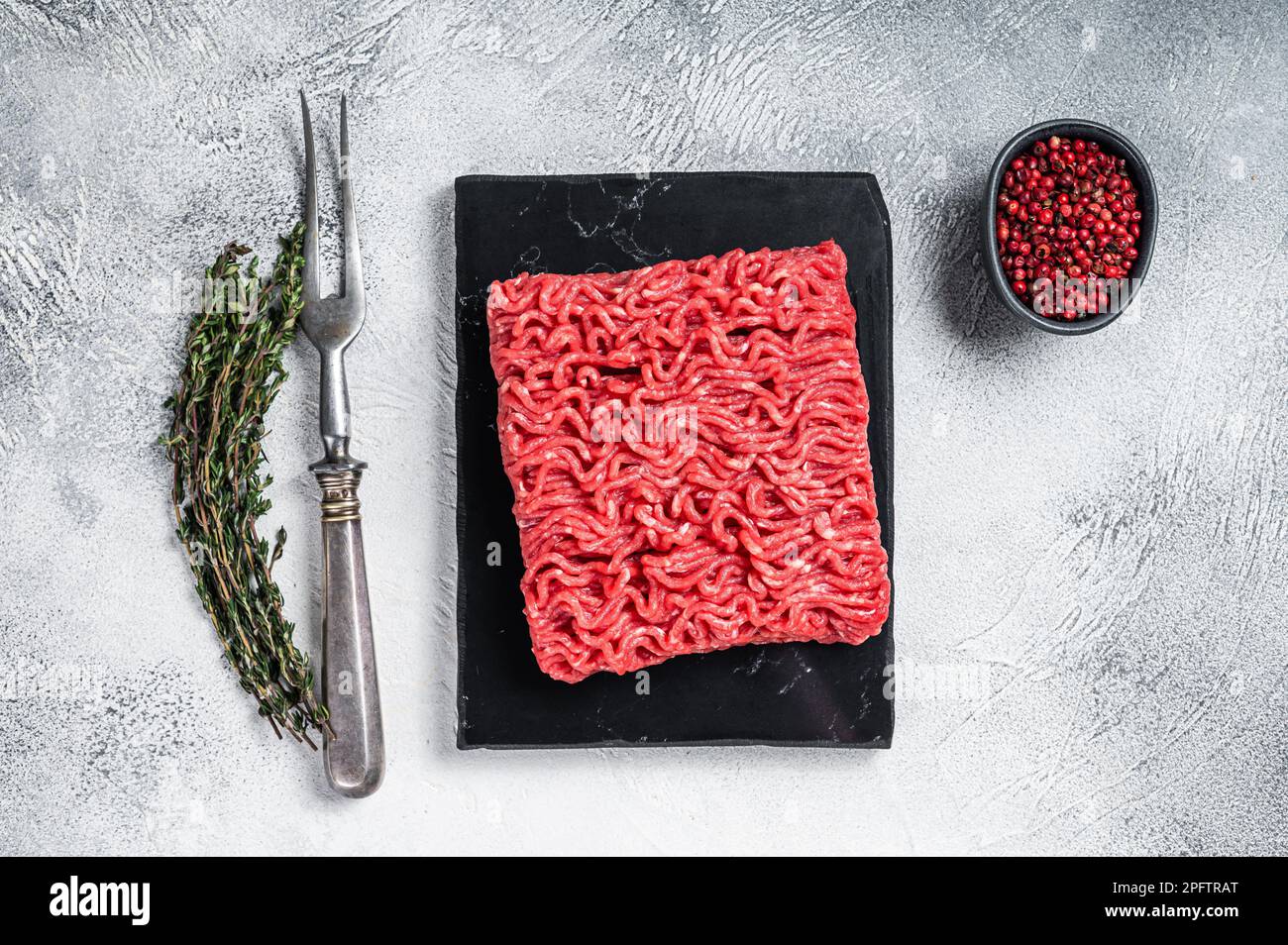 Raw mince Minced beef, ground meat with thyme and pepper. White ...