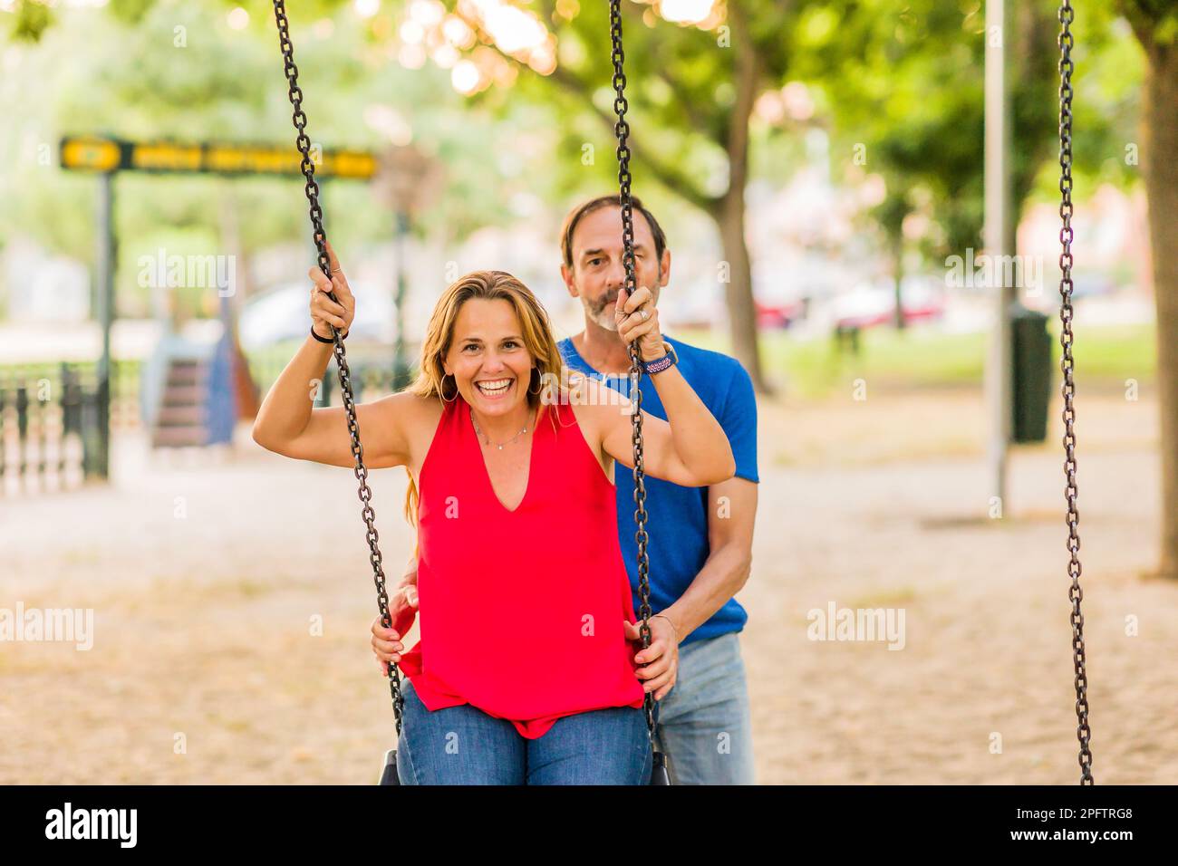 married mature 50s couple enjoy happy in playground swing. Seniors ...