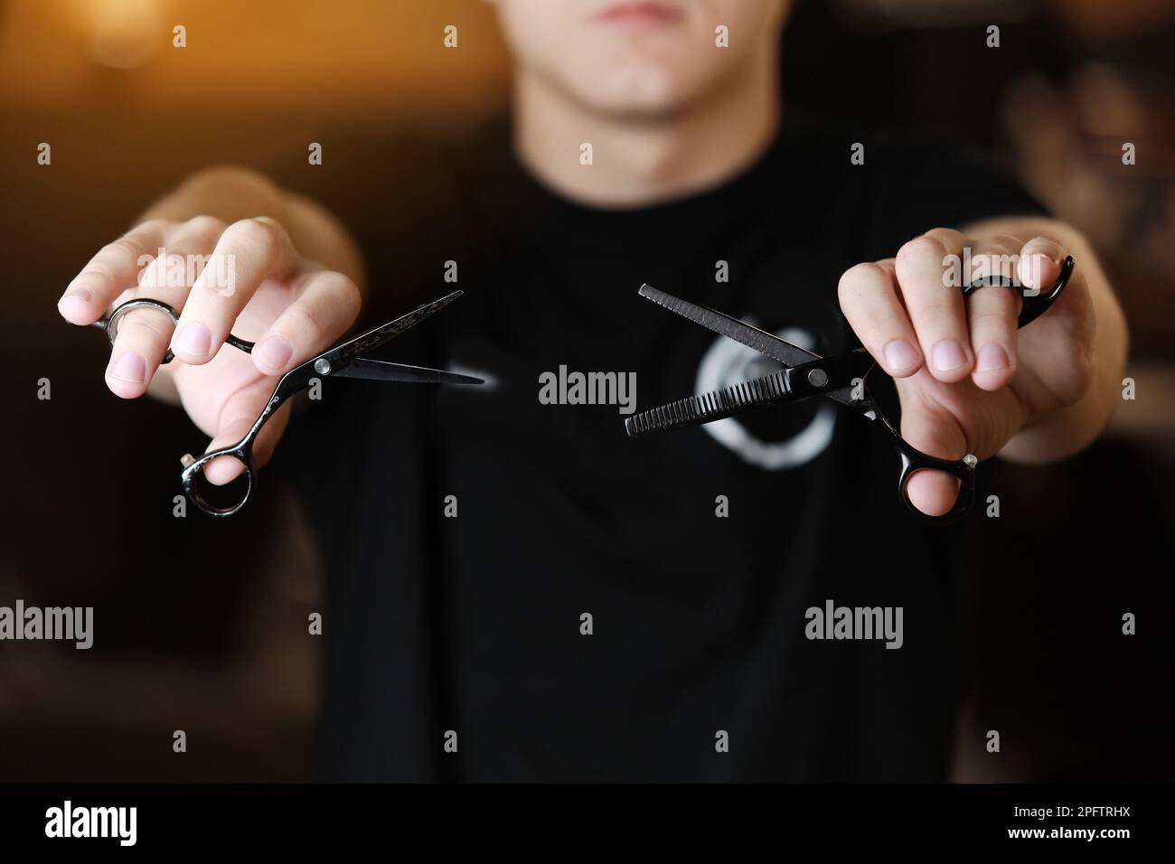 Barbershop. Unrecognisable hairdresser is holding two type of scissors ...