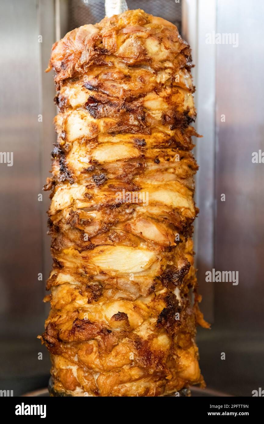 Juicy Greek traditional gyros grilled on fire and chopped by a knife ...