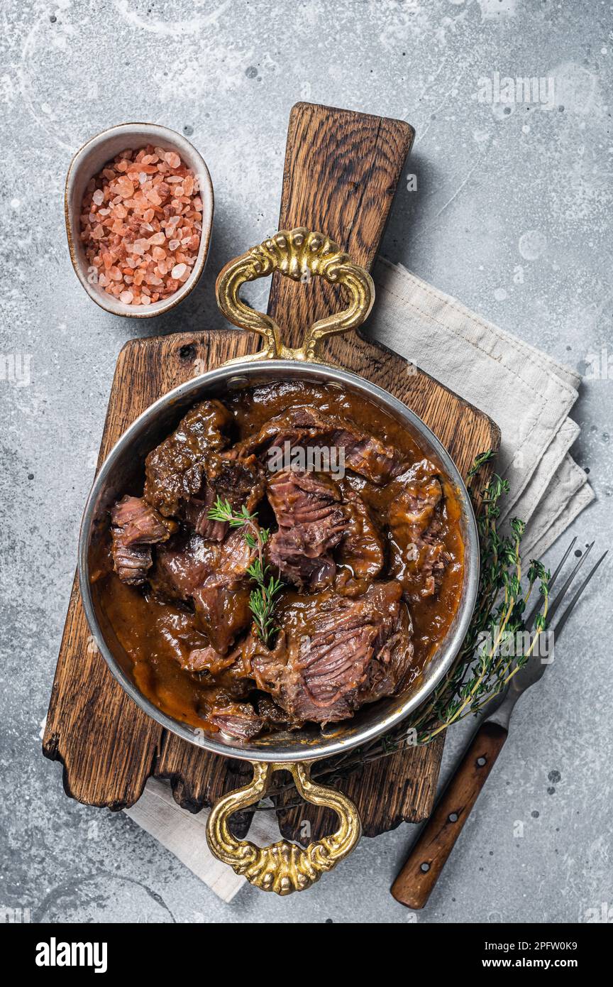 German braised beef cheeks in brown red wine sauce. Gray background ...