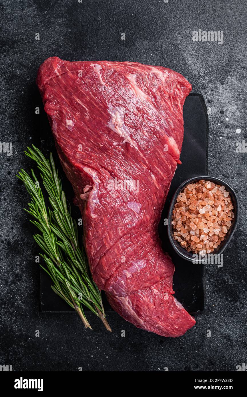 Raw American Tri Tip beef steak on marble board. Black background. Top ...