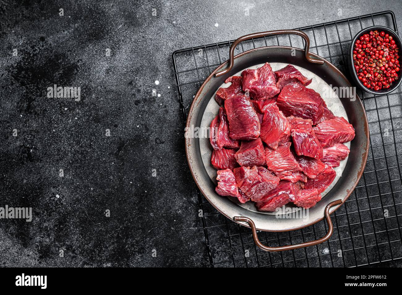 Raw Diced venison dear meat for a goulash, game meat. Black background ...
