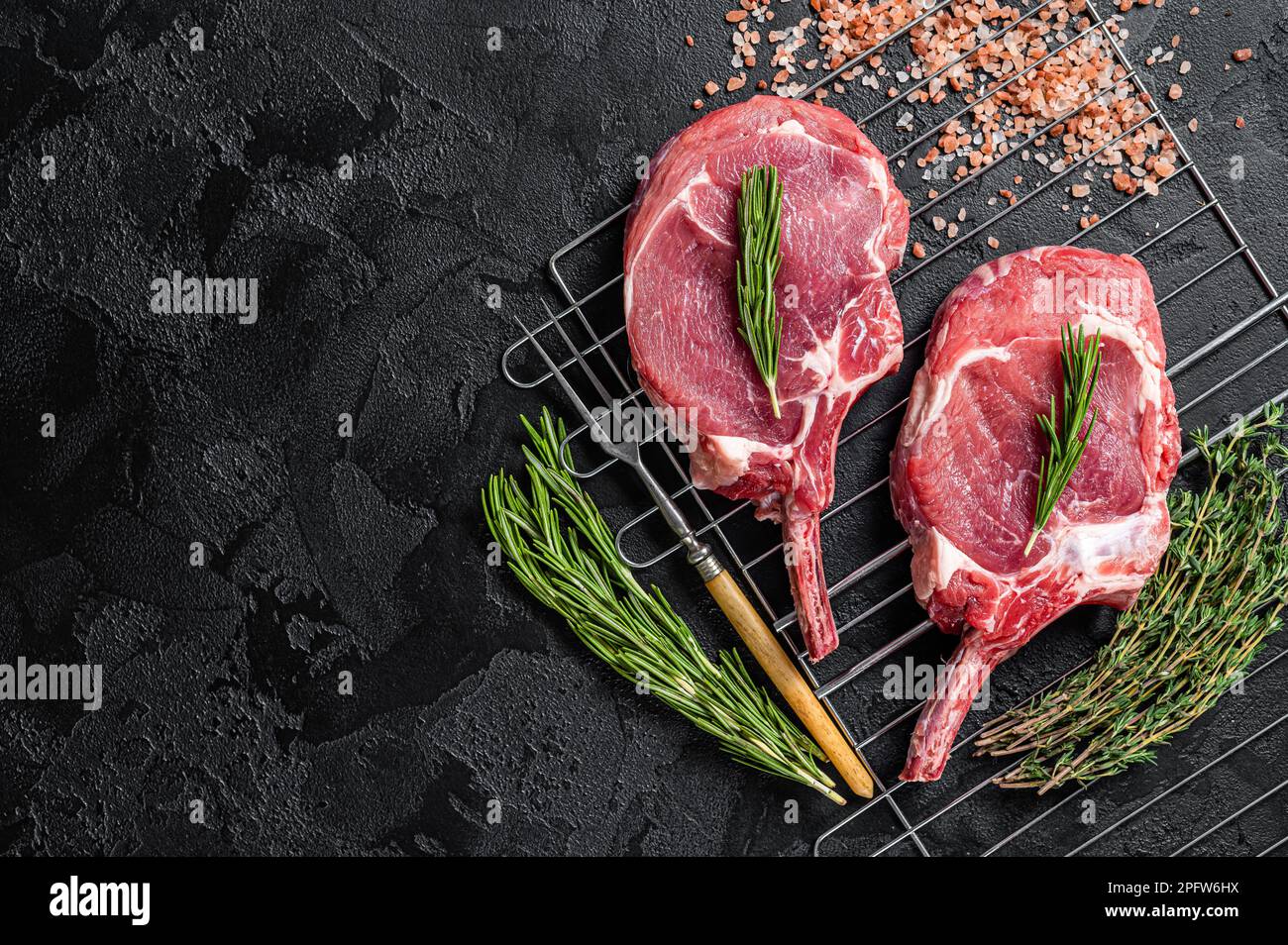 Fresh Raw Tomahawk rib eye beef steaks on grill. Black background. Top ...
