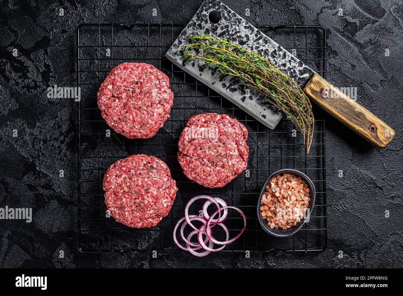 Raw minced beef cutlets with spices and herbs ready for cooking. Black ...