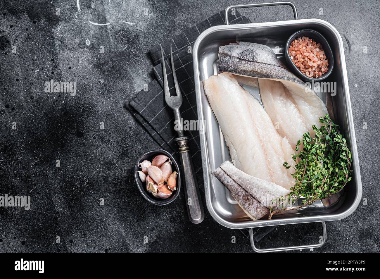 Raw haddock fish fillets, whitefish meat in kitchen tray with thyme ...