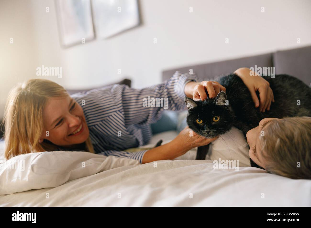 Mom teaching child boy to stroke animal correctly gently while lying on ...