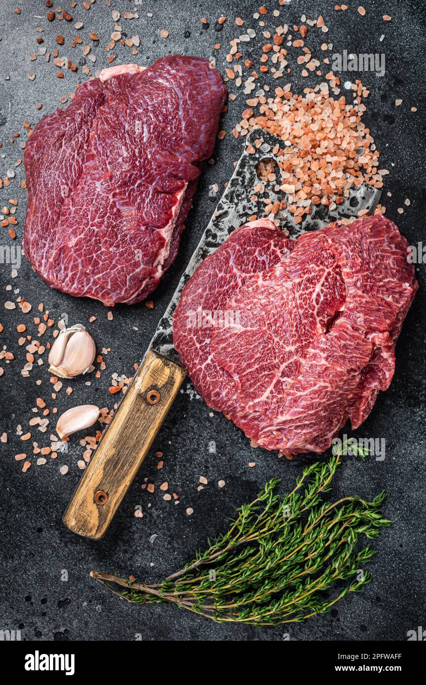 Raw Beef cheeks, fresh veal meat on butcher cleaver. Black background ...