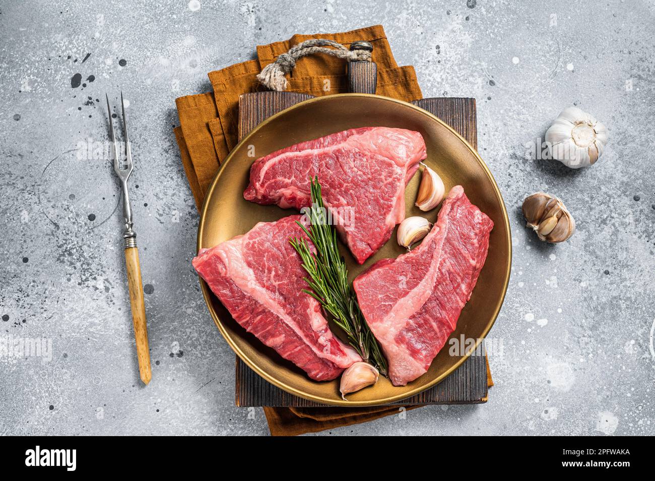 Raw Topside sirloin beef cut on steel plate with spices. Gray ...