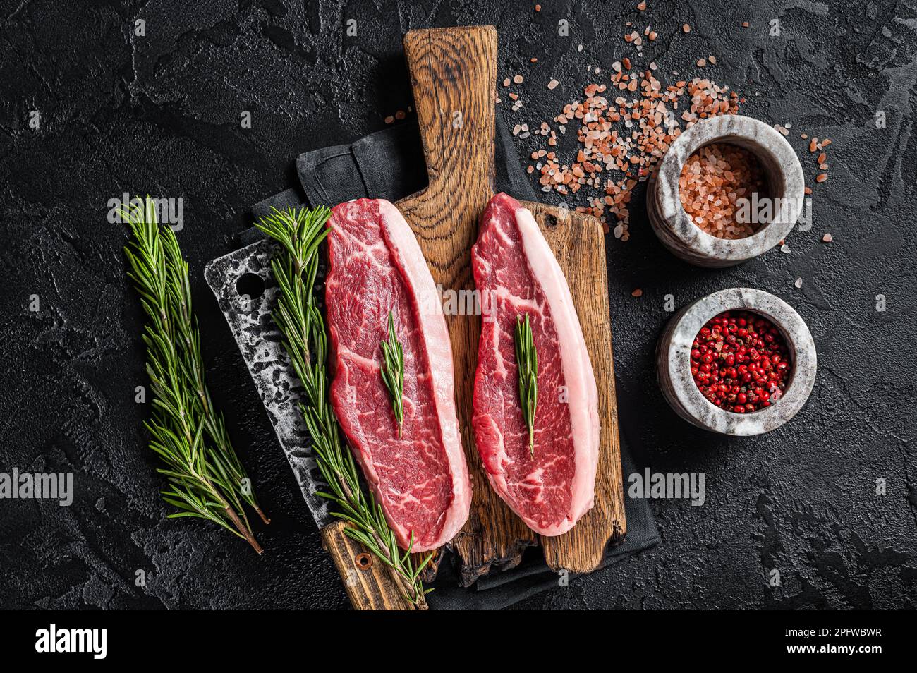 Raw cap rump beef meat steak or top sirloin on butcher board. Black ...