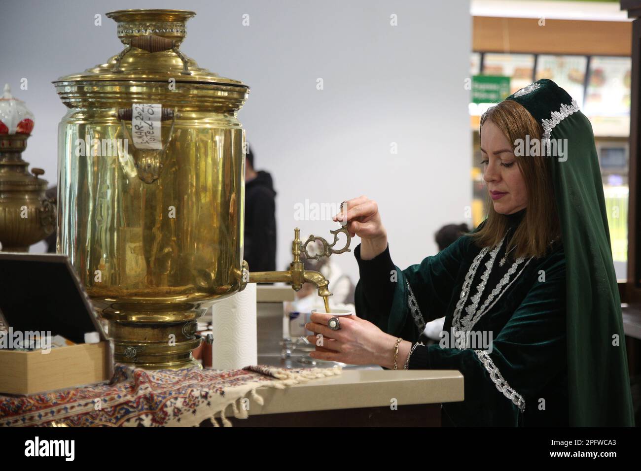 Iranian women serve tea from a traditional samovar during Nevruz ...