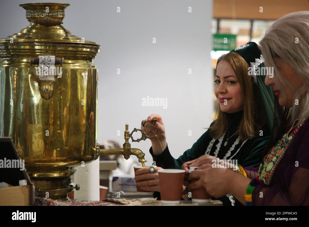 Iranian women serve tea from a traditional samovar during Nevruz ...