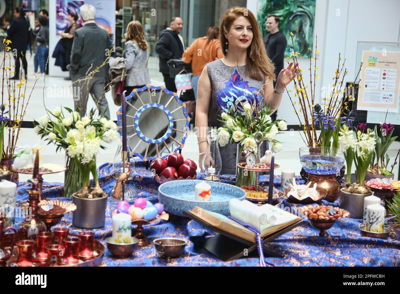 Iranian woman poses by traditional items adorning a Haft Sin (Haft Seen ...