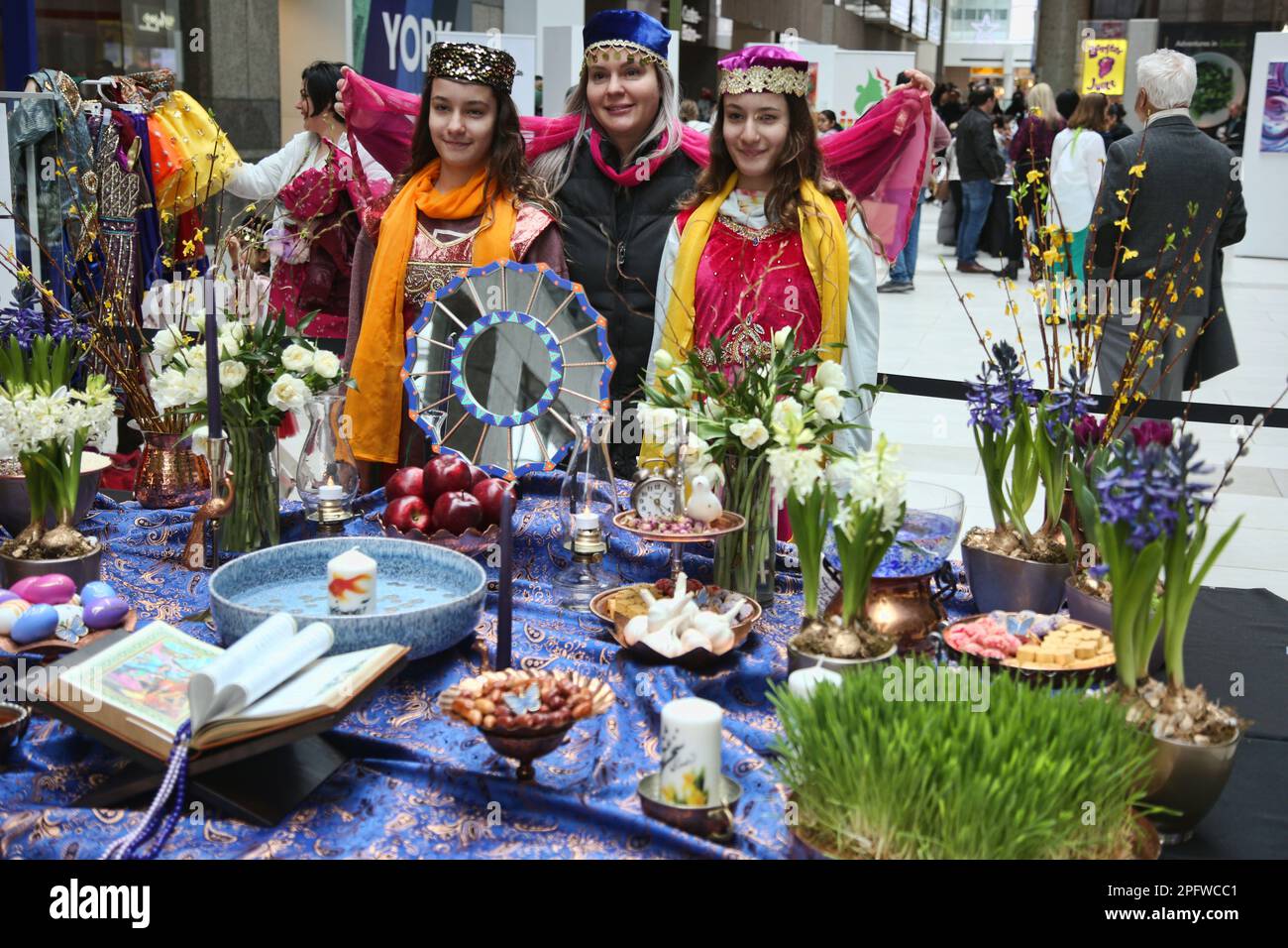 Iranians pose by a tradtional a Haft Sin (Haft Seen) (an arrangement of ...