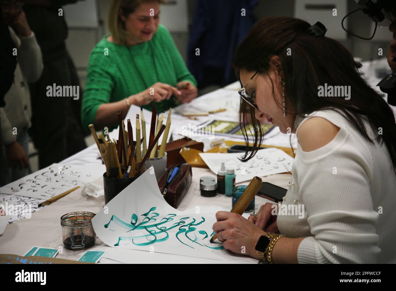People take part in a traditional Farsi calligraphy workshop during ...