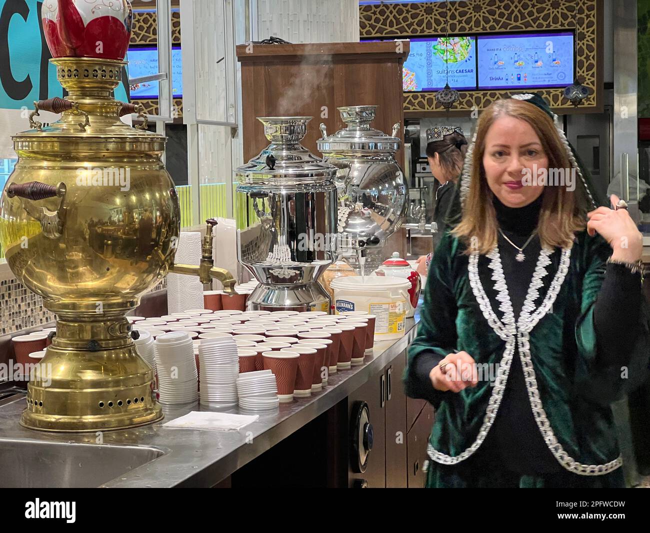 Iranian women serve tea from a traditional samovar during Nevruz ...