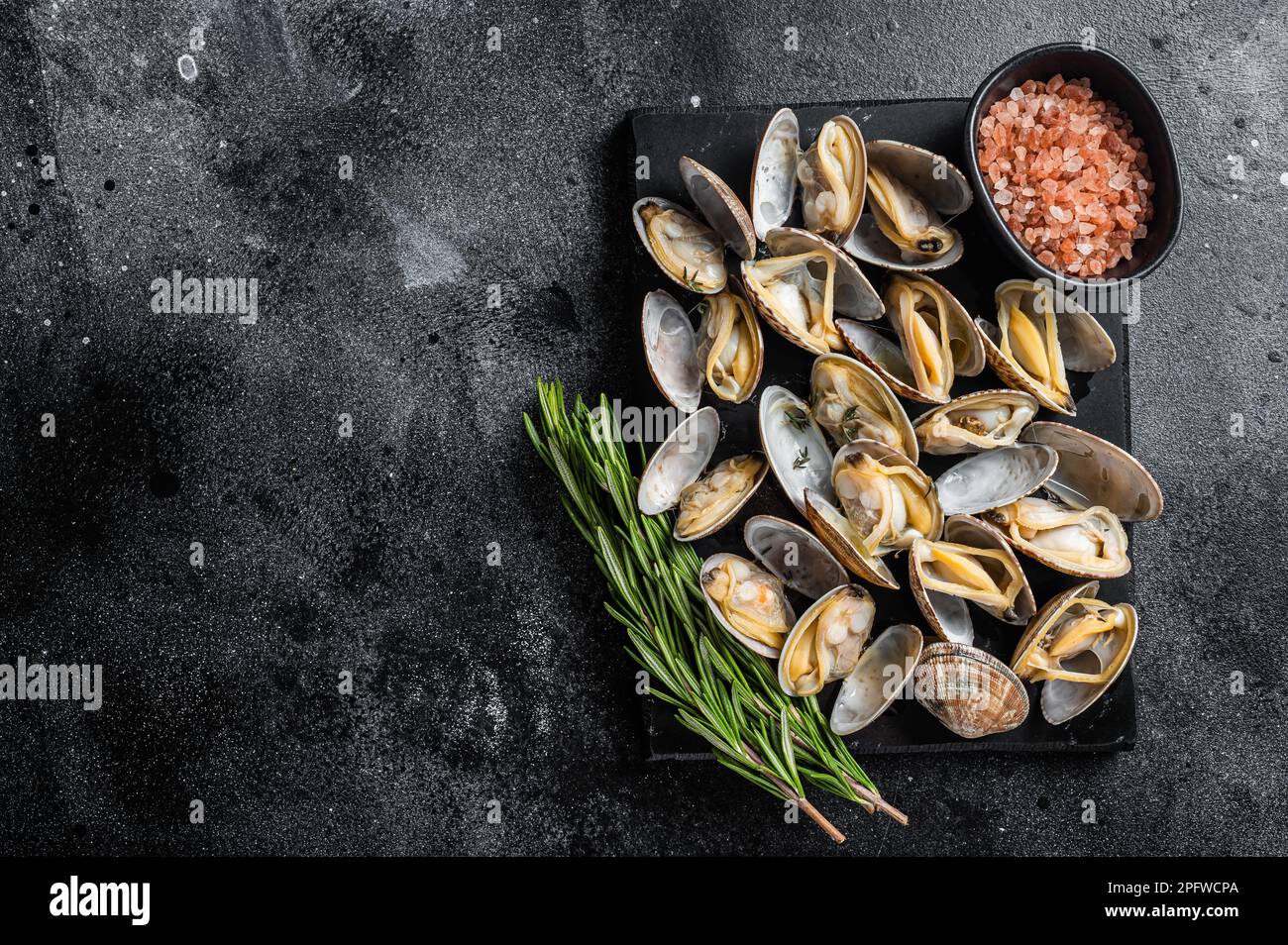 Steamed shellfish Clams with garlic and herbs. Black background. Top ...
