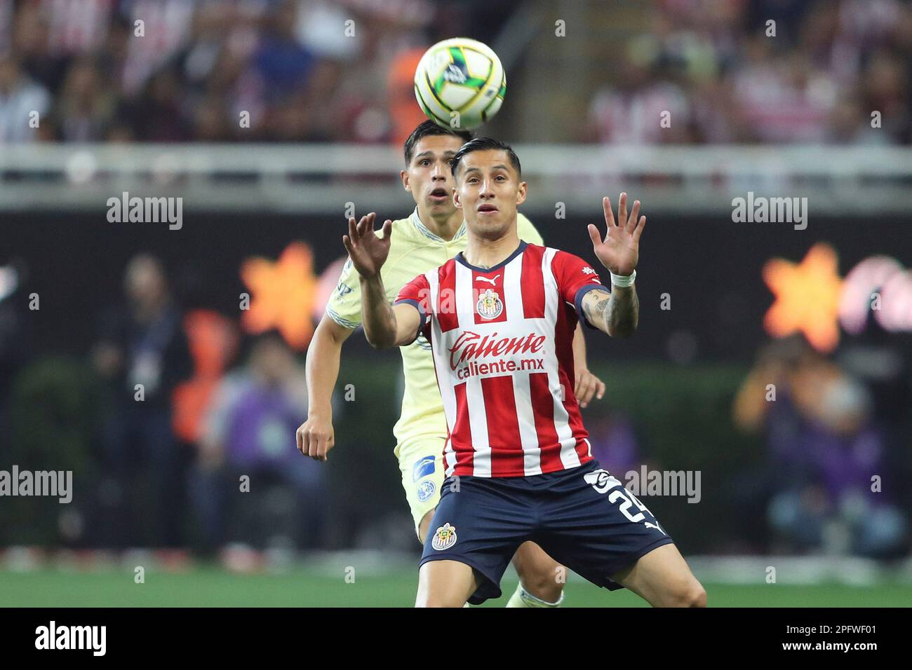 Chivas' Carlos Cisneros, front, controls the ball challenged by America ...