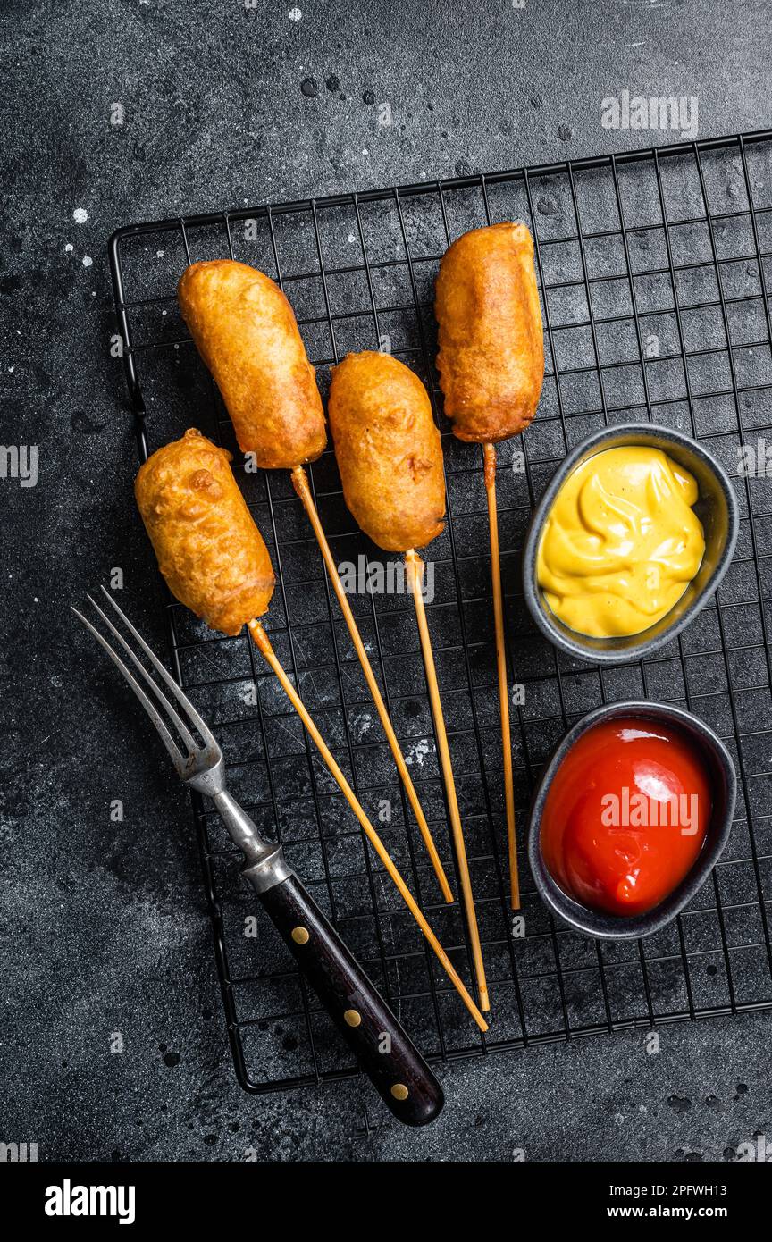 Deep fried corn dogs with mustard and ketchup. Black background. Top ...