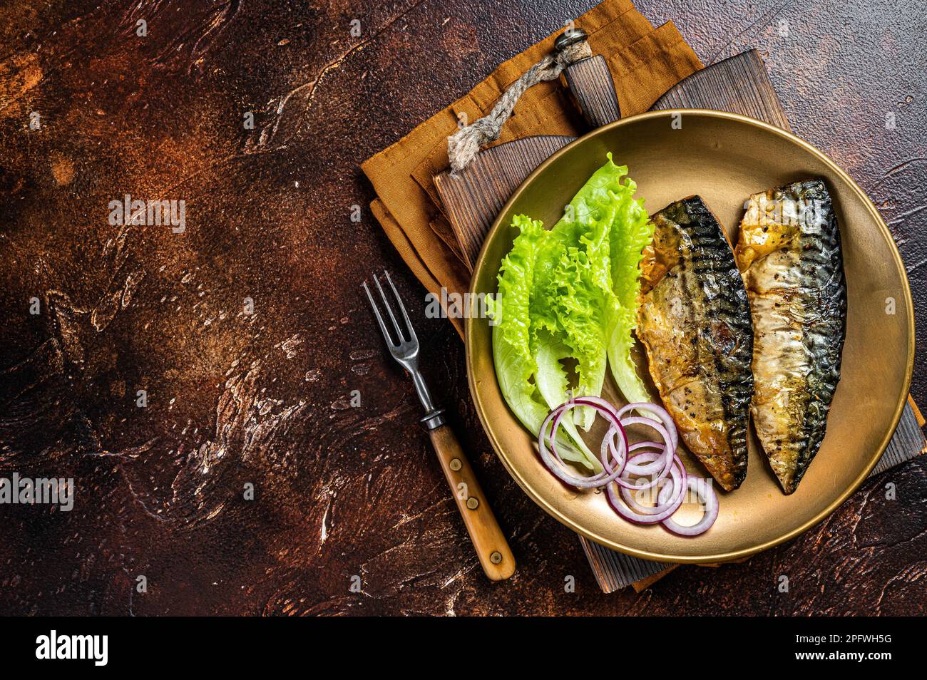 Grilled mackerel scomber fish fillets with garnish in a plate. Dark ...