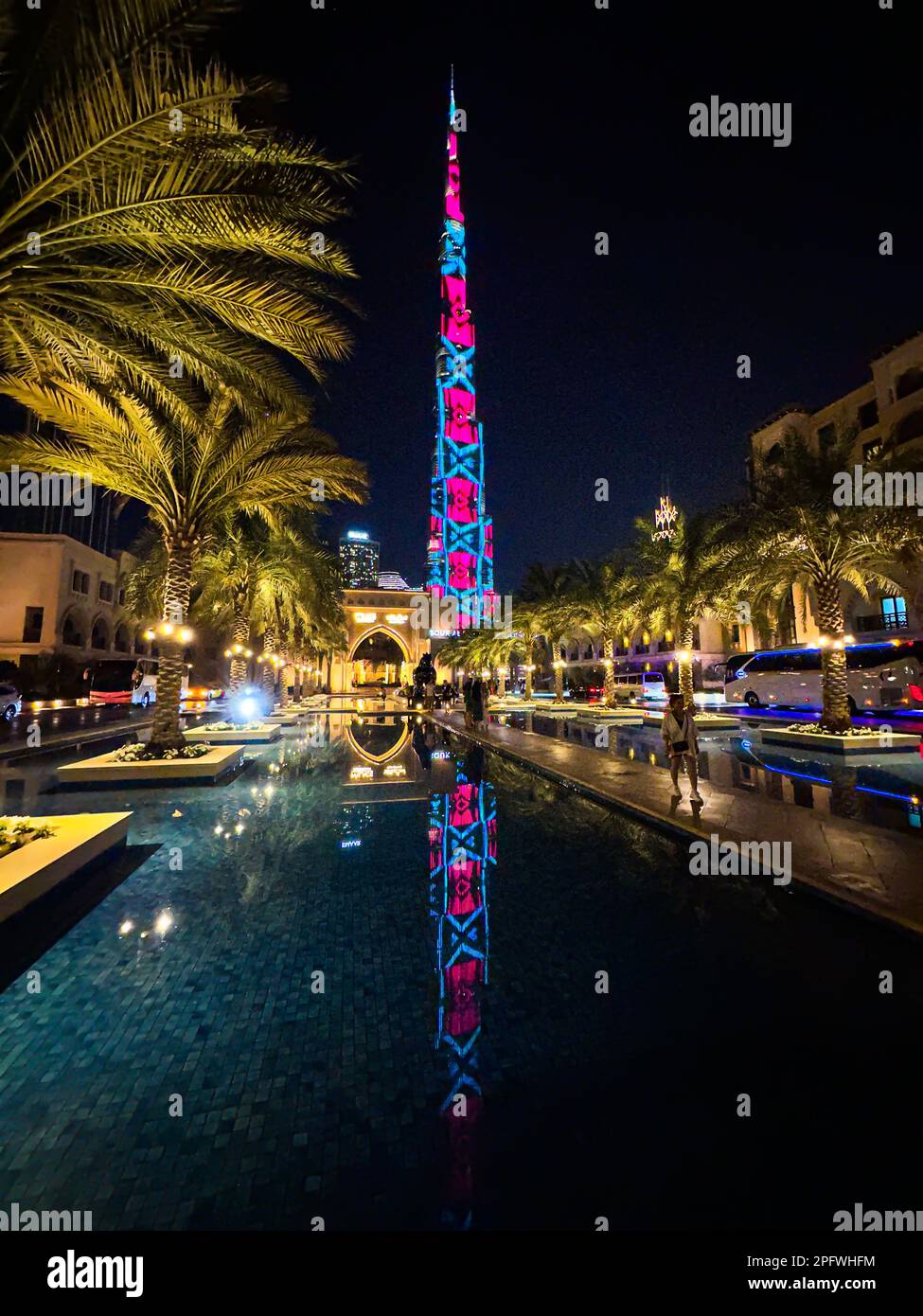Dubai Downtown. square place with palm trees and pond with burj khalifa ...