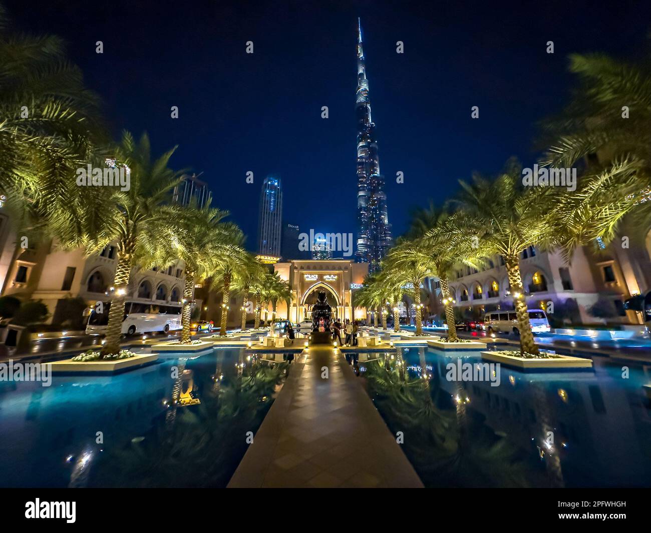 Dubai Downtown. square place with palm trees and pond with burj khalifa ...