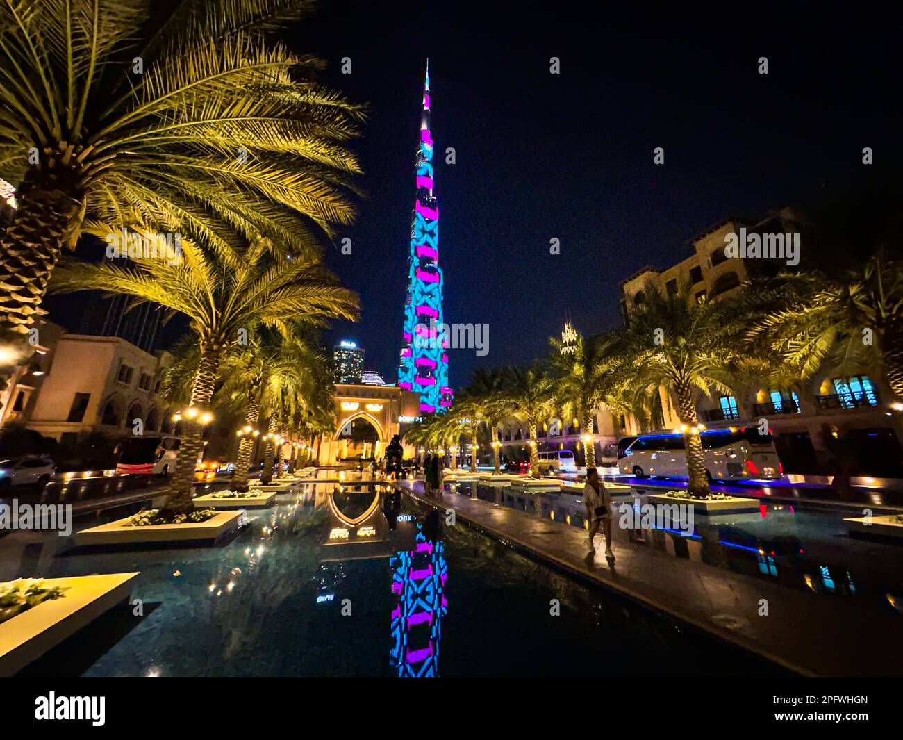Dubai Downtown. square place with palm trees and pond with burj khalifa ...