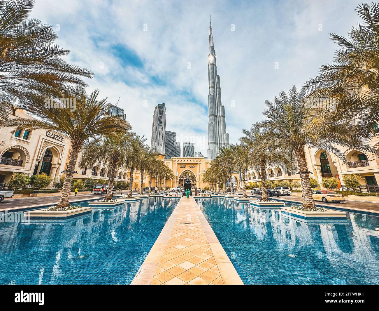 Dubai Downtown. square place with palm trees and pond with burj khalifa ...