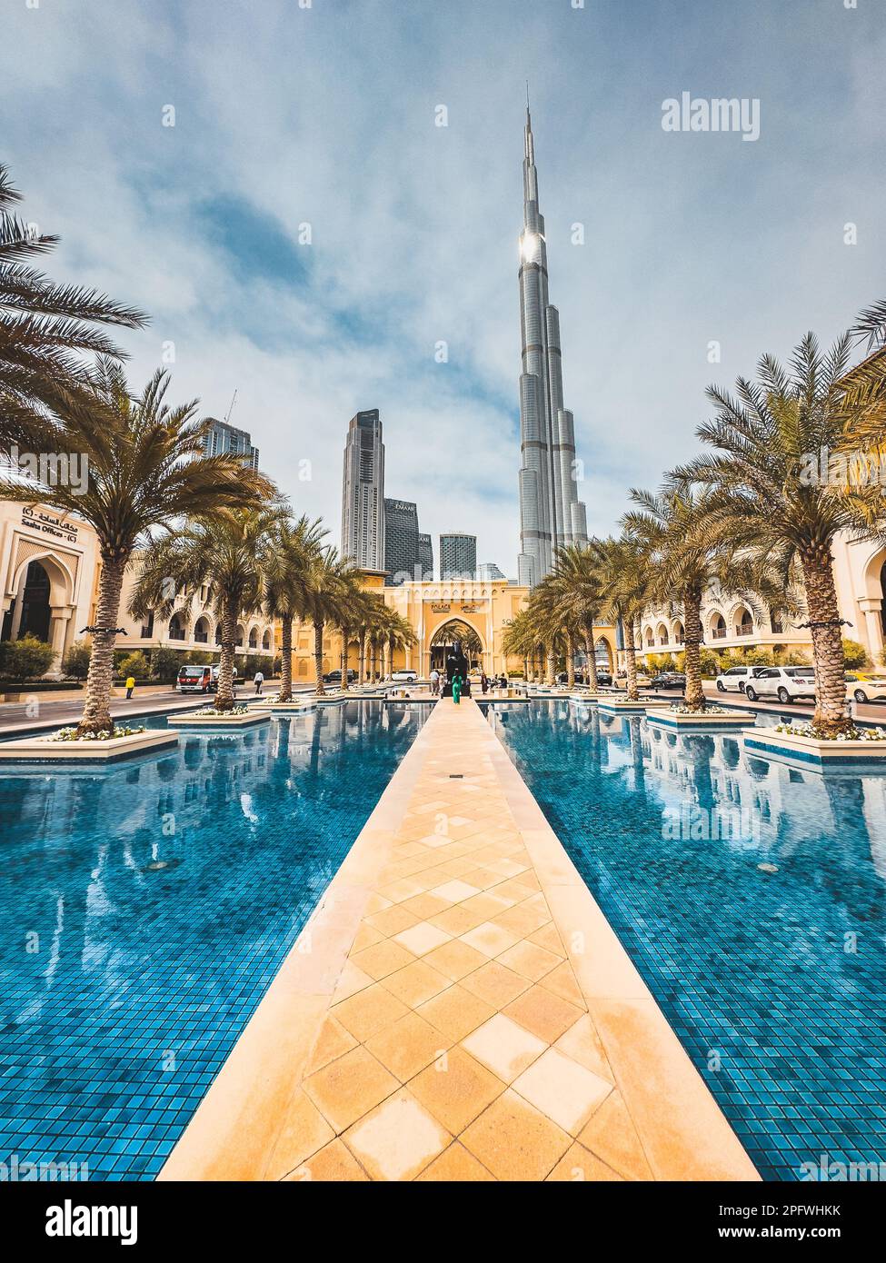 Dubai Downtown. square place with palm trees and pond with burj khalifa ...