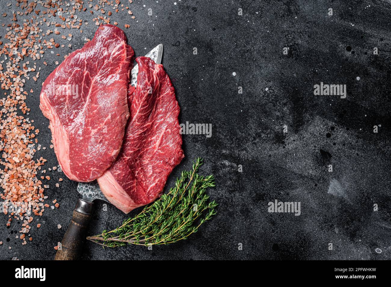 Butcher choise beef raw steaks on butcher knife. Black background. Top ...