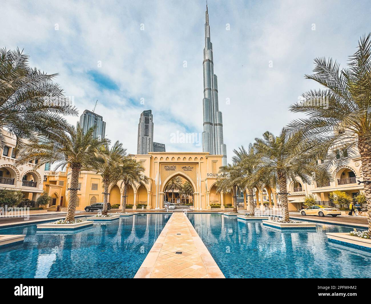Dubai Downtown. square place with palm trees and pond with burj khalifa ...