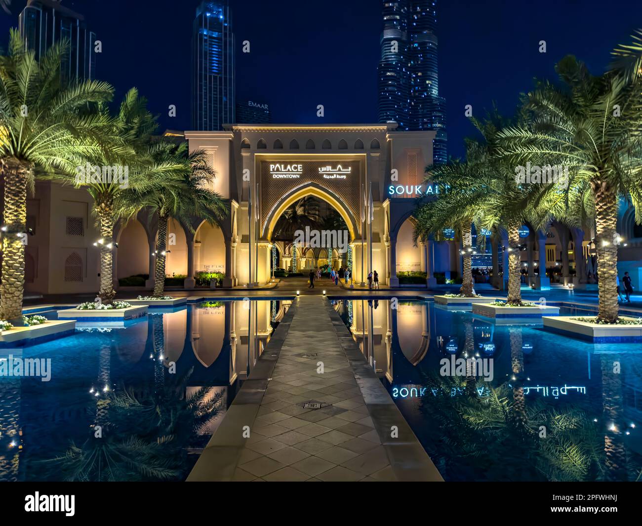 Dubai Downtown. square place with palm trees and pond with burj khalifa ...